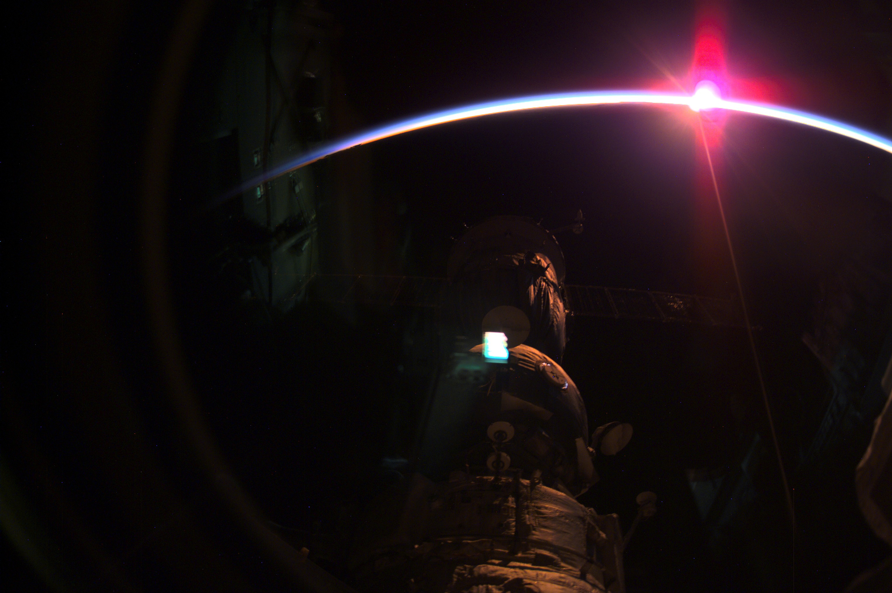 The setting sun and the thin blue airglow line at Earth's horizon ...
